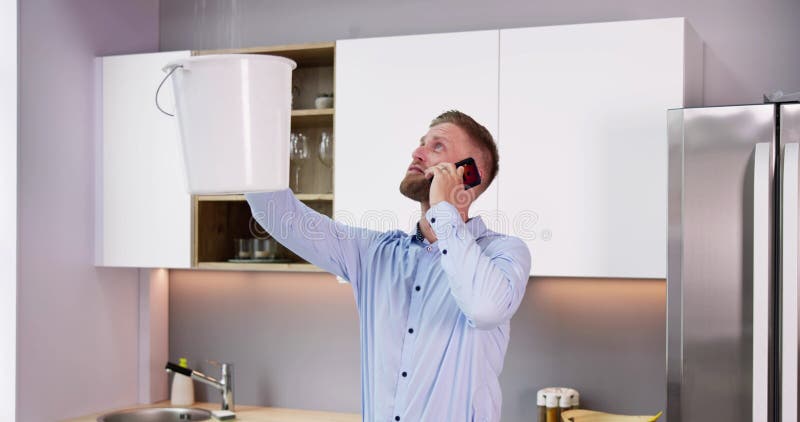 Man Calling Plumber while Collecting Water Leaking from Ceiling Stock ...