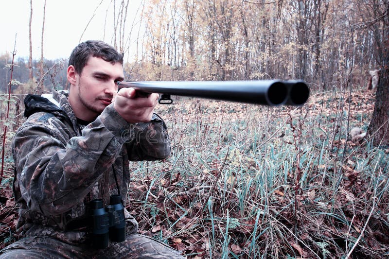 A Man in Camouflage and with a Hunting Rifle in a Forest on a Sp Stock ...
