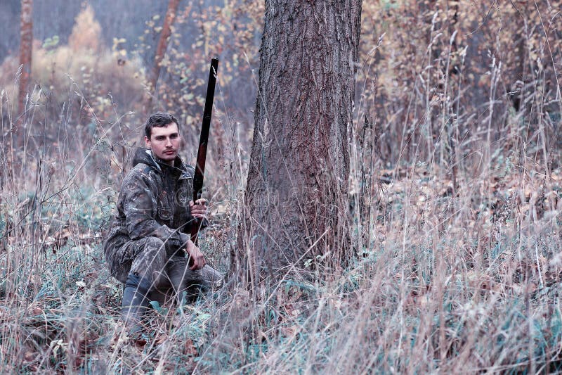A Man in Camouflage and with a Hunting Rifle in a Forest on a Sp Stock ...