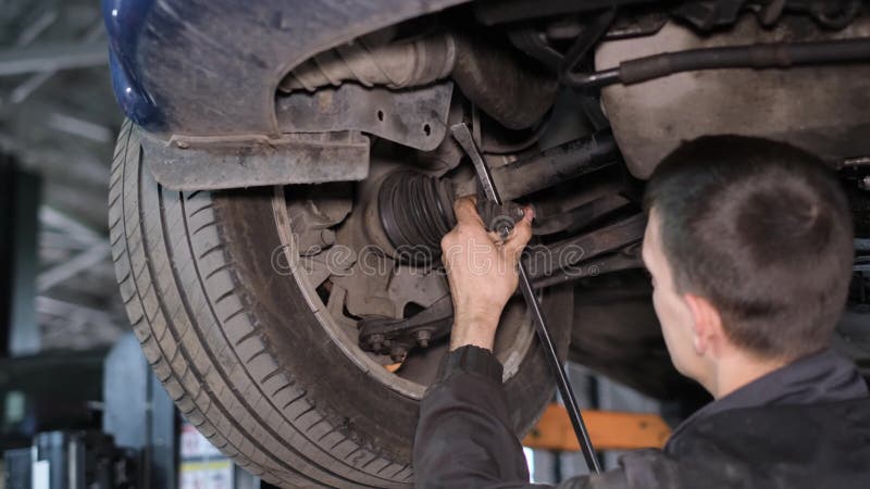 Man Car Mechanic with Tools Inspects the Car S Running System. Worker ...