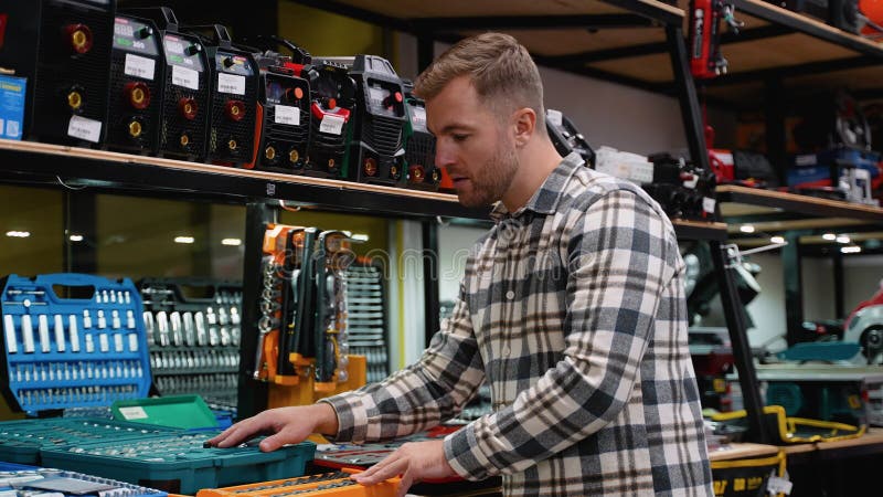 A Man Carefully Inspects a Large Tool Set in a Hardware Store Stock ...