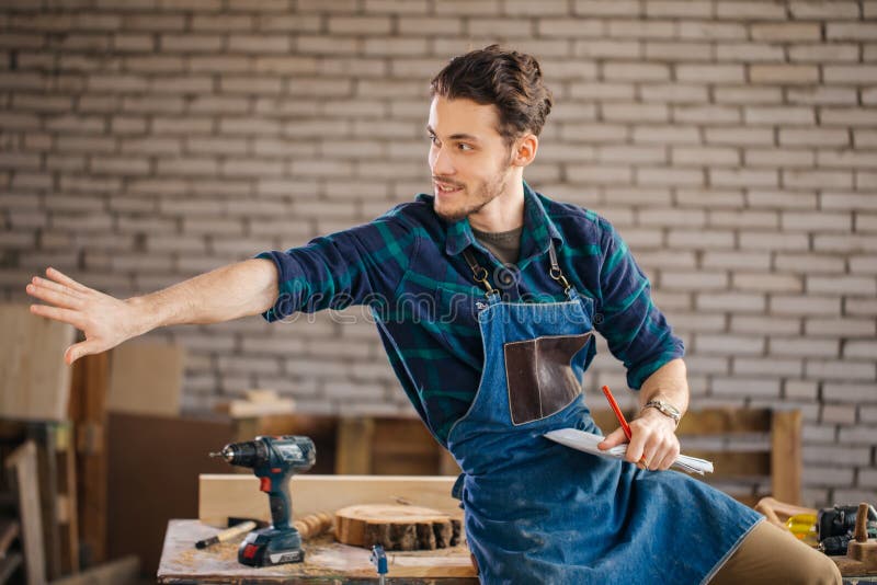 Man Carpenter in His Home Studio Draws Sketches in Pencil in Notebook ...
