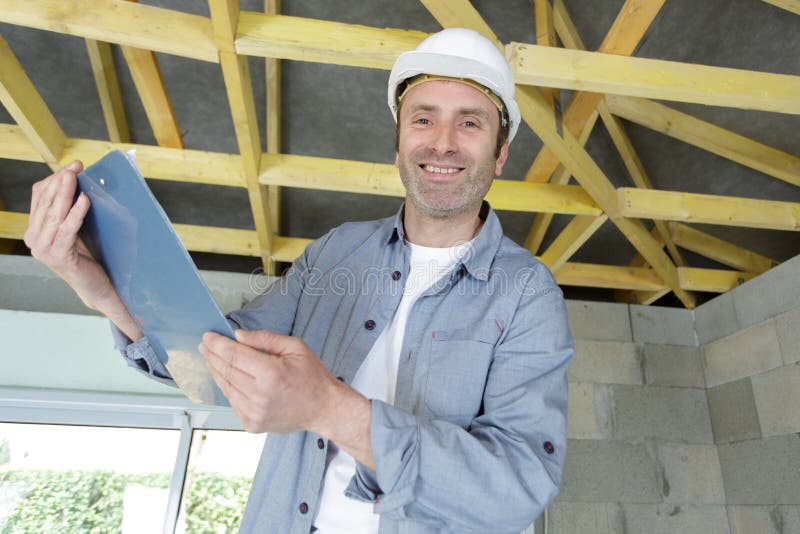 Man Carpenter Holding Clipboard at Construction Site Stock Photo ...