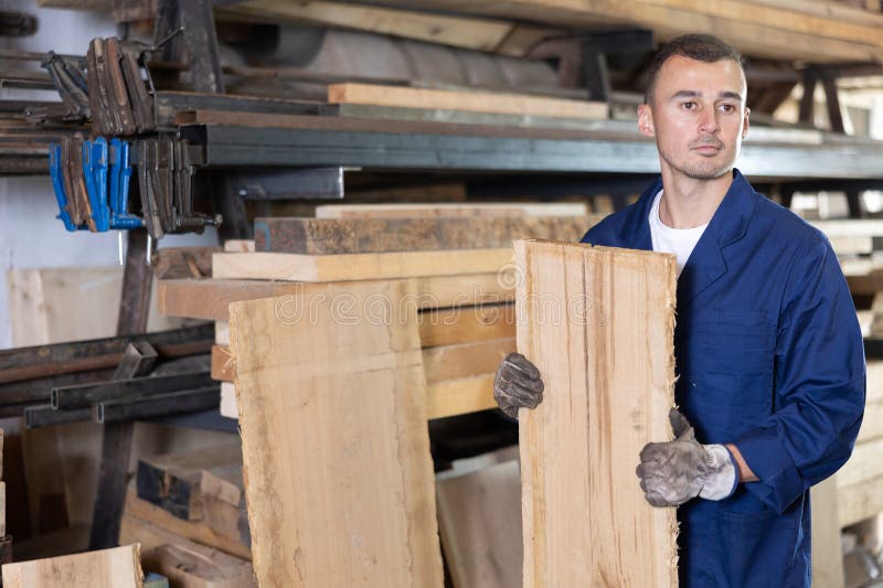 Man Employee of Carpentry Workshop Takes Out Necessary Board from Stack ...