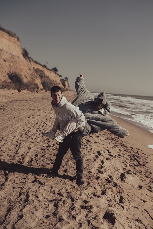 Man Carries His Girlfriend On Back Couple Having Fun On The Seashore