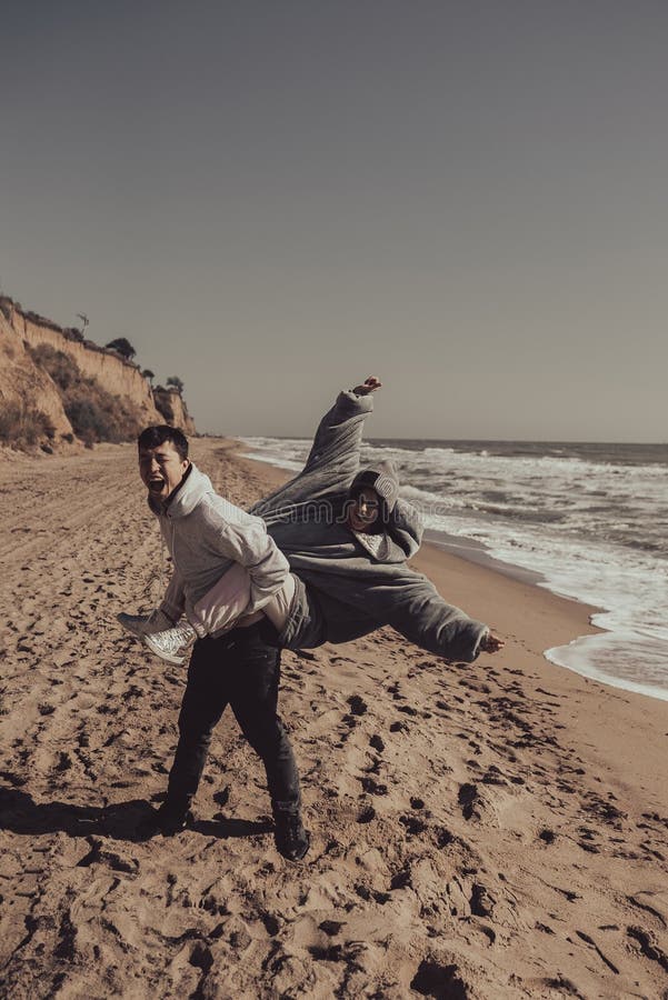 Man Carries His Girlfriend On Back Couple Having Fun On The Seashore