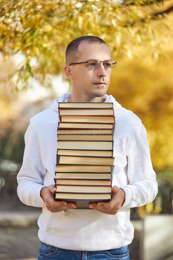 Man Carries a Lot of Books in His Hands. a Stack of Textbooks for ...