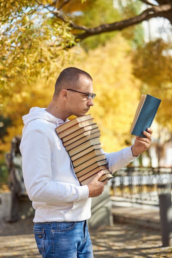 Man Carries a Lot of Books in His Hands. a Stack of Textbooks for ...