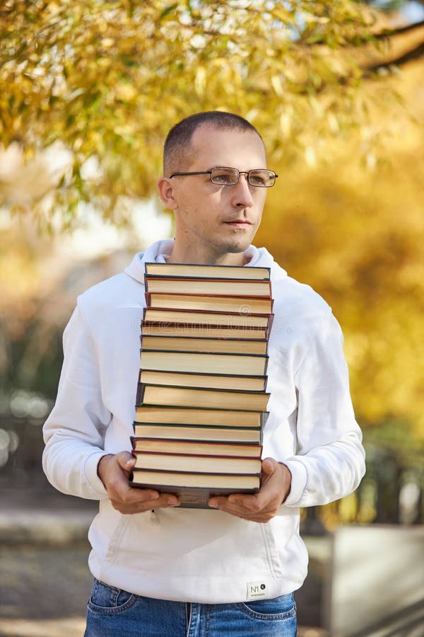Man Carries a Lot of Books in His Hands. a Stack of Textbooks for ...