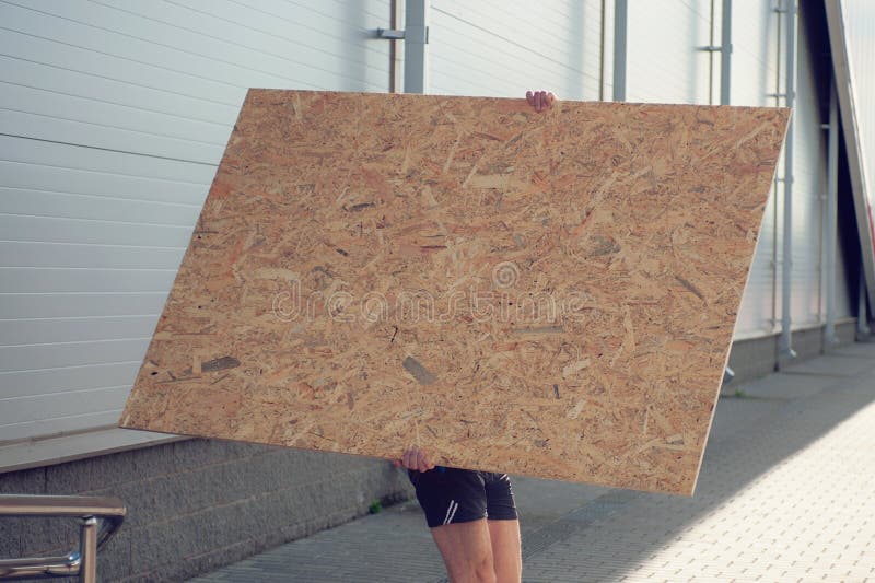A Man Carries a Wooden Plate for Construction Stock Photo - Image of ...