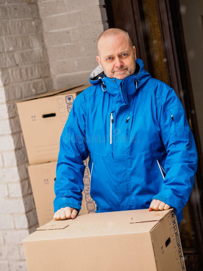 Man carrying moving boxes stock photo. Image of snowfall - 67138416