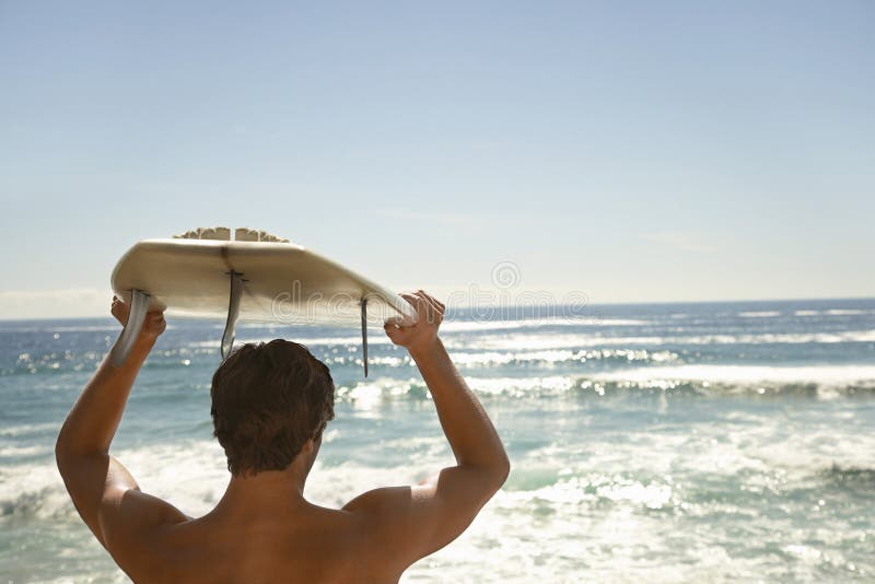 Man Carrying Surfboard Above Head by Ocean Stock Photo - Image of hobby ...