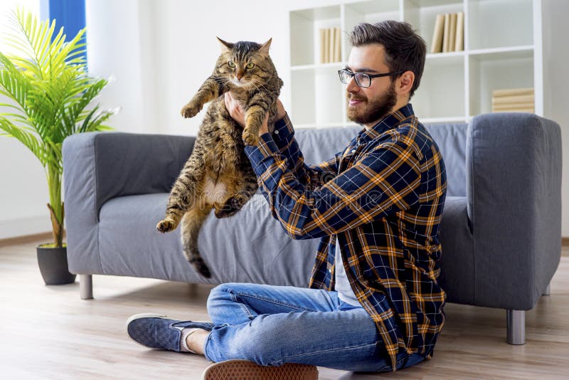 Man with a cat stock photo. Image of cheerful, interior - 99303634