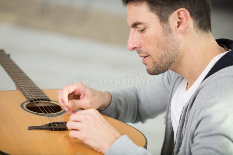 Man changes guitar strings stock photo. Image of equipment - 275986994