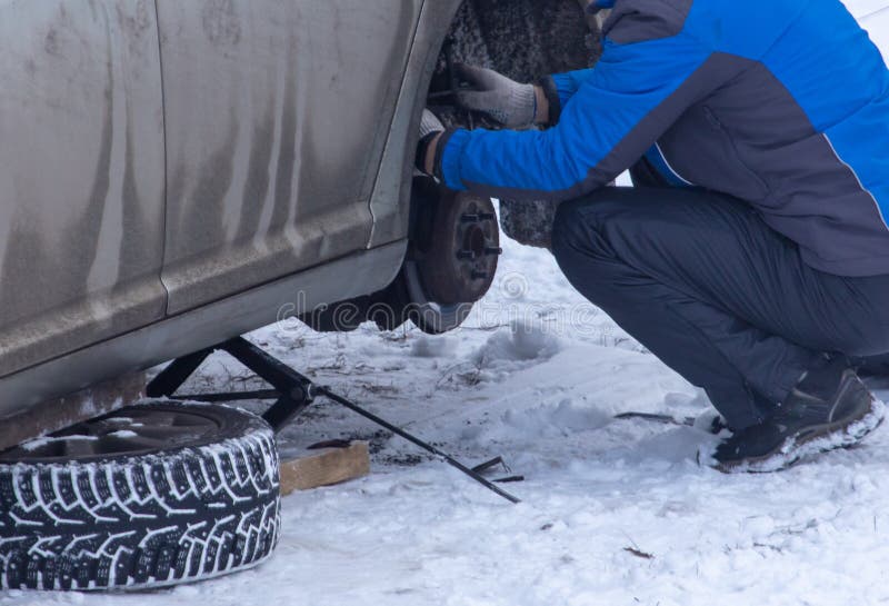 A Man Changes a Wheel To a Car in the Snow Stock Photo - Image of wheel ...