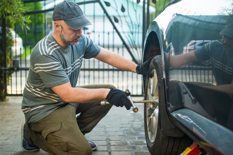 Man Changing Car Wheels at His Backyard. Technician Using Tools To Fix ...
