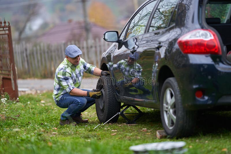 Man changing a flat tyre stock photo. Image of repair - 202646946