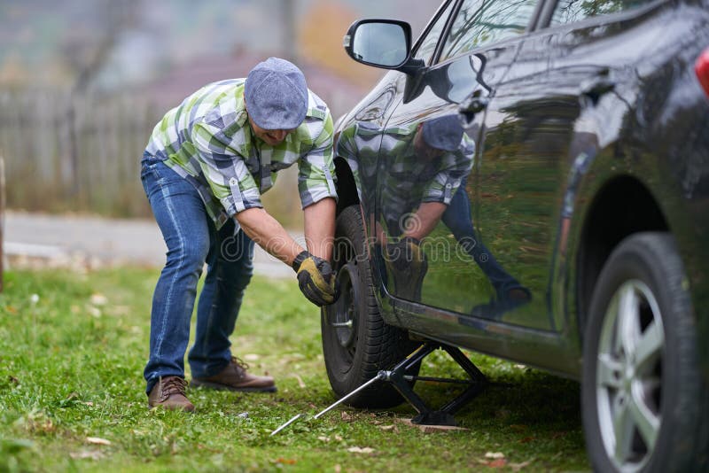 Man changing a flat tyre stock photo. Image of repair - 202646970