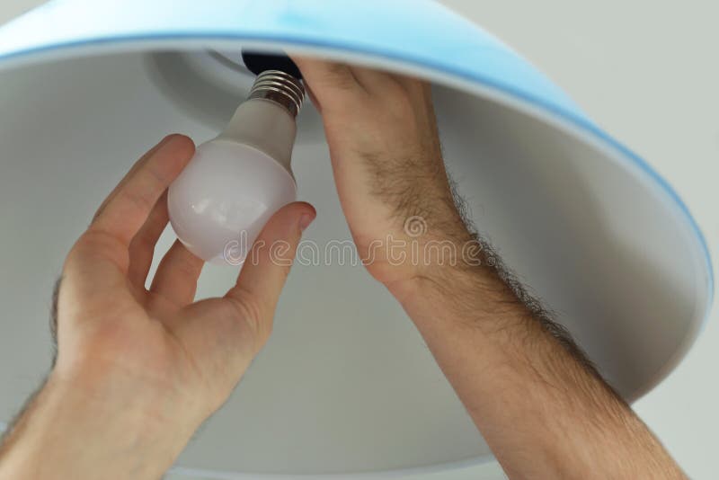 Man Changing Light Bulb in Lamp Stock Photo - Image of green, bulb ...