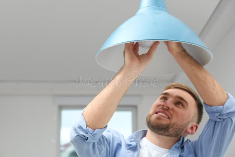 Man Changing Light Bulb in Lamp Stock Photo - Image of caucasian ...