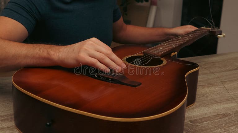 Man Changing the Strings of a Guitar at Home. Man S Hand are Installing ...