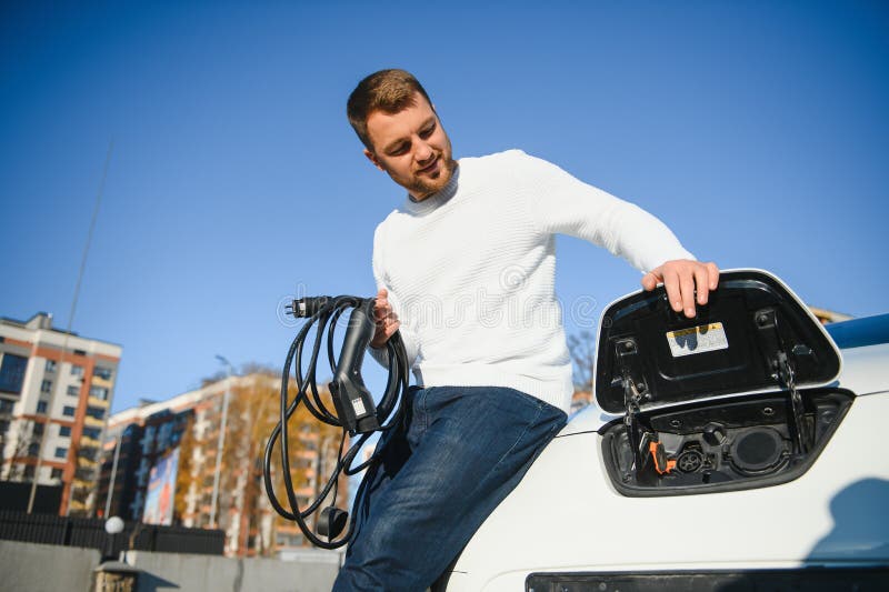 Man Charges an Electric Car at the Charging Station Stock Photo - Image ...