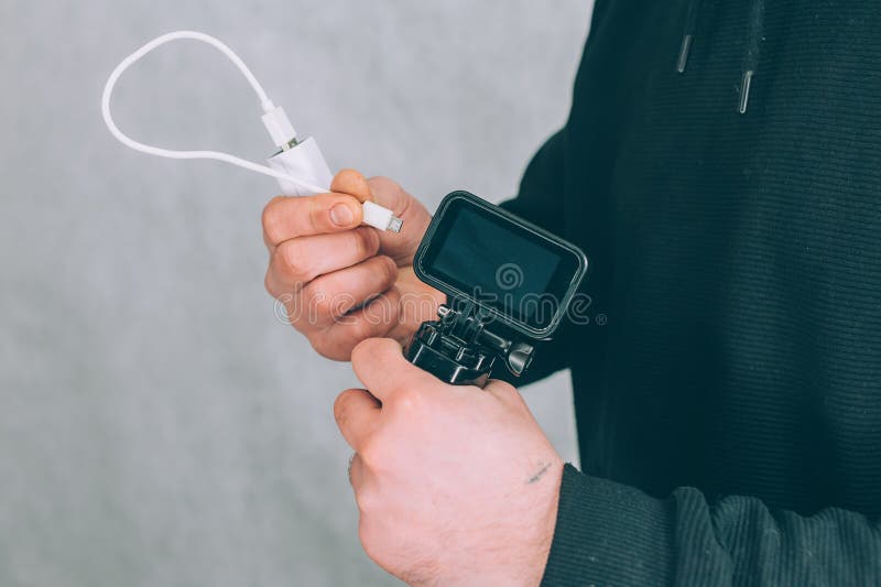 A Man is Charging an Action Camera with a Portable Charger Stock Photo ...