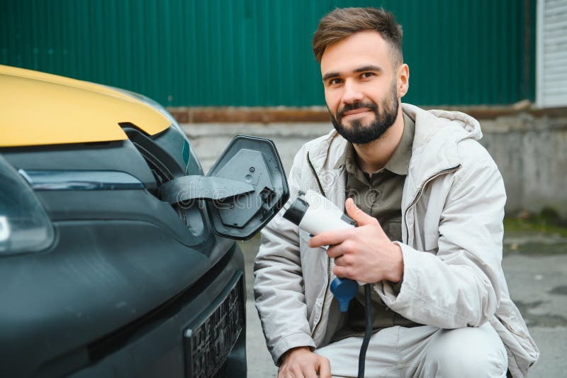 Man Charging Electric Car by the Work Stock Image - Image of electric ...