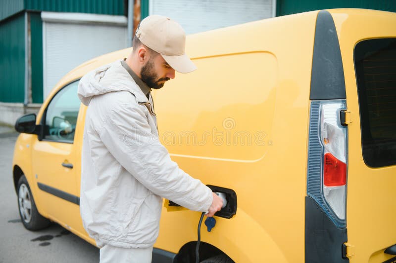 Man Charging Electric Car by the Work Stock Image - Image of cable ...