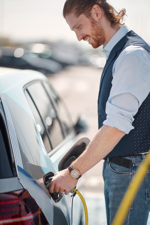 Man Charging His Non-polluting Electric Vehicle Stock Photo - Image of ...