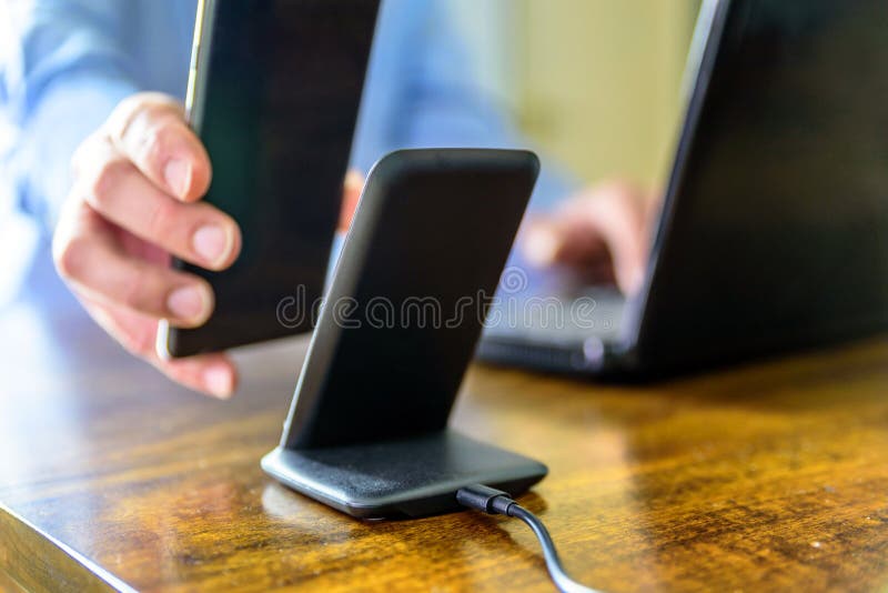 Man Charging Smartphone Using Wireless Charging Stand at Home Office ...