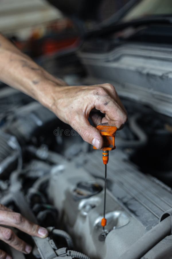 A Man is Checking the Engine Oil on a Car for a Replacement. Stock ...