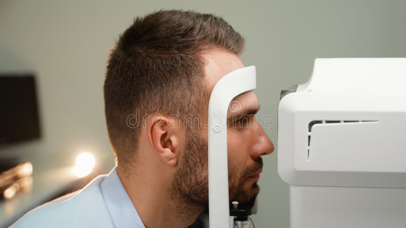 A Man Checking Eye Vision on Optometry Equipment. Eyesight Exam Stock ...