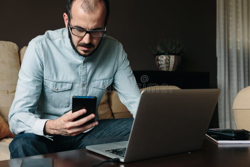 Man Checking His Phone while is Working from Home Stock Image - Image ...