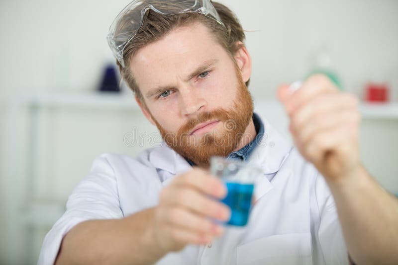 Man Checking Liquid through Magnifying Glass Stock Photo - Image of ...