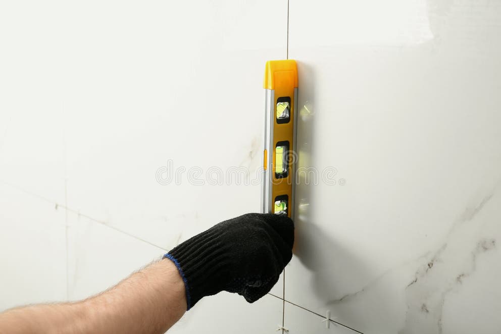 Man Checking Proper Ceramic Tile Installation with Level on Wall ...