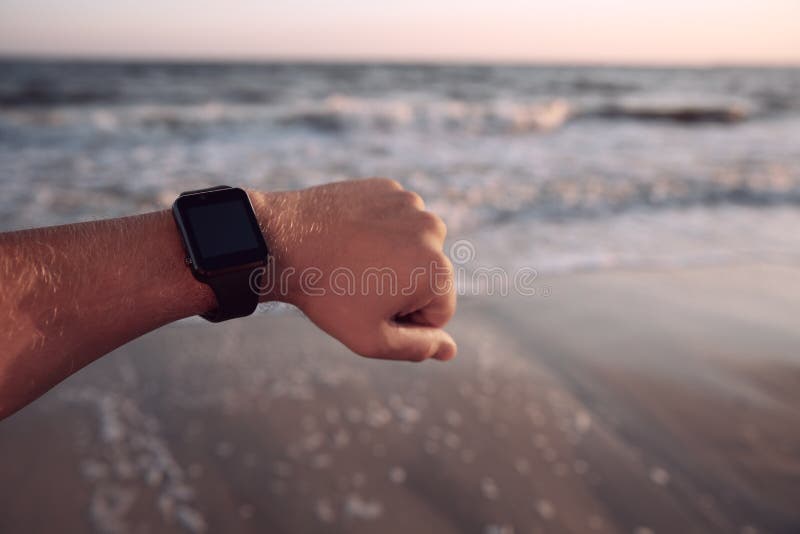 Man Checking Smart Watch on Beach at Sunset, Closeup Stock Photo ...