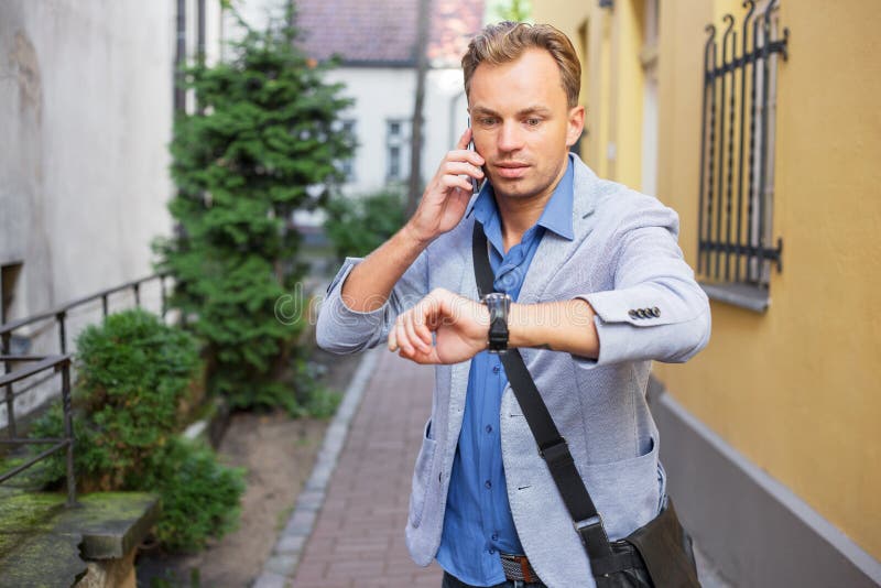 Man Checking Time on His Watch and Talking on the Phone Stock Photo ...