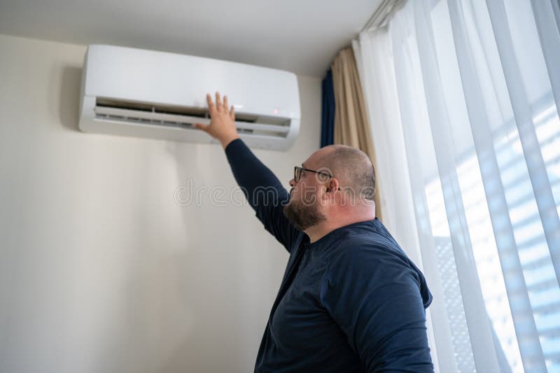 Man Checking Working Air Conditioner Touching Air by Hand in Summer Hot ...