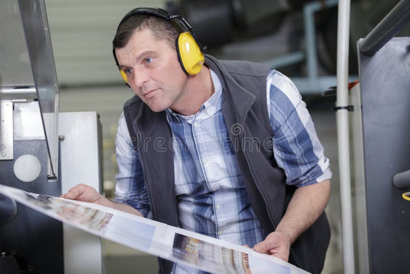 Man checks print quality stock image. Image of workshop - 244997693