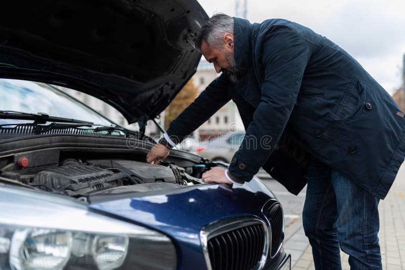 A Man Checks the Technical Condition of the Car before the Trip ...