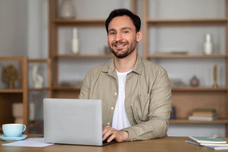 Smiling Man Sitting at Desk with Laptop Stock Image - Image of ...