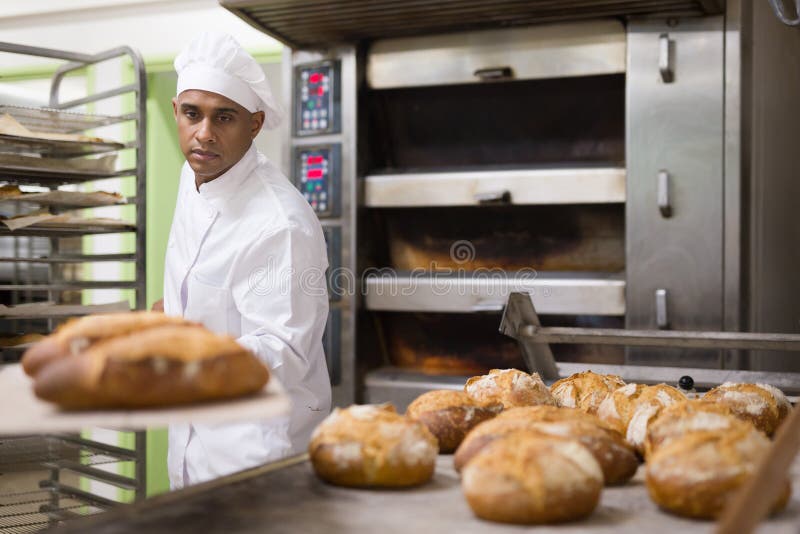 Male Baker with Bread on Baking Shovel in Kitchen Stock Photo - Image ...