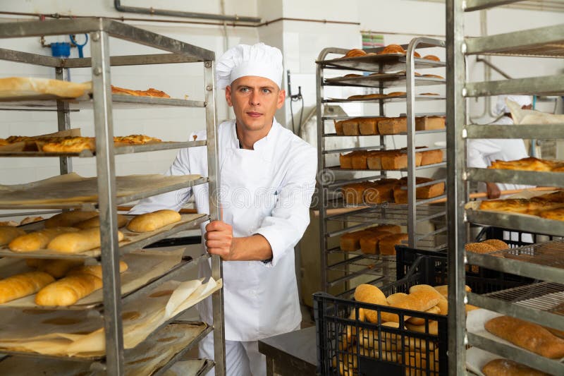 Man in Chefs Uniform Rolling Trolley with Bread in Bakery Stock Image ...