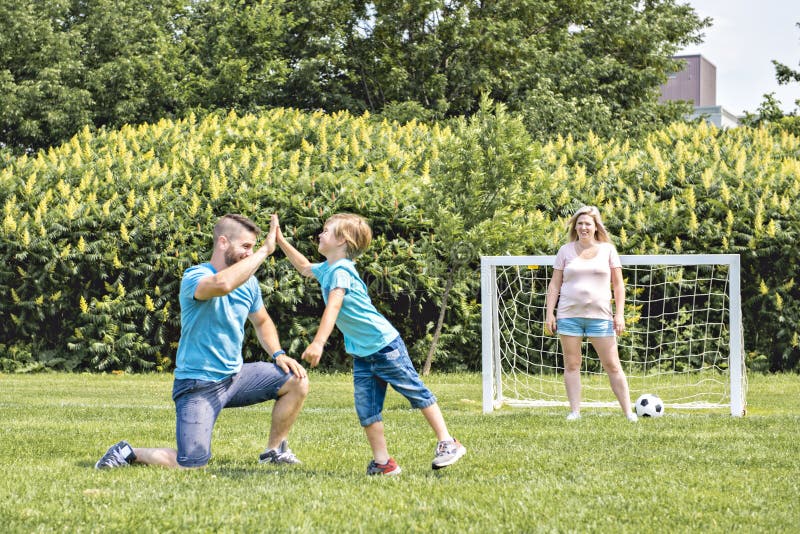 Man with Child Playing Football Outside on Field Stock Photo - Image of ...
