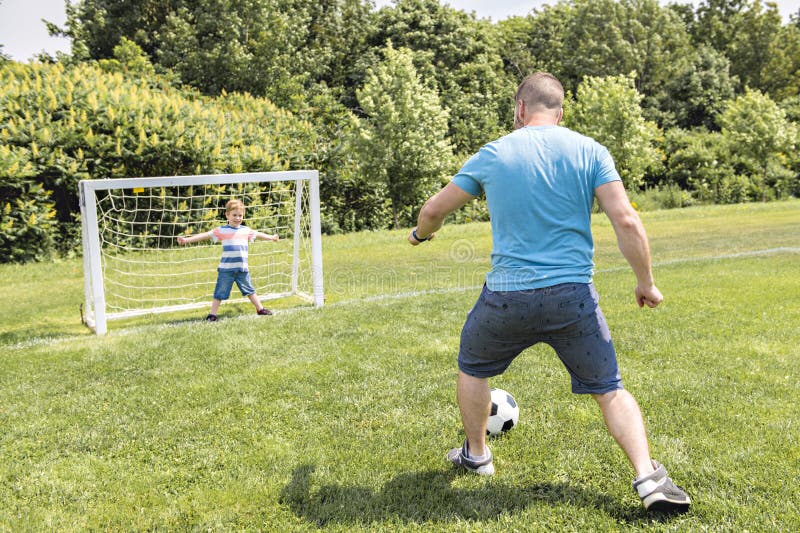 Man with Child Playing Football Outside on Field Stock Photo - Image of ...
