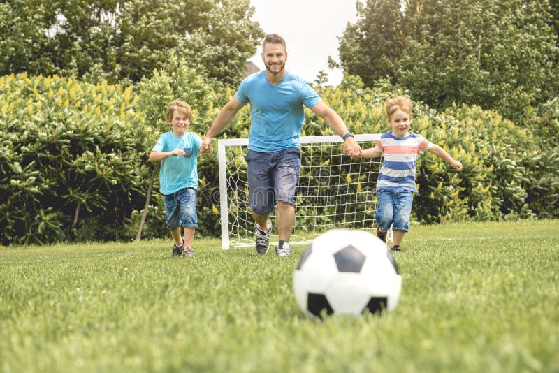 Man with Child Playing Football Outside on Field Stock Image - Image of ...