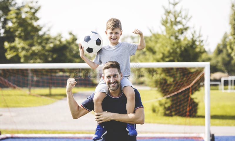Man with Child Playing Football Outside on Field Stock Photo - Image of ...