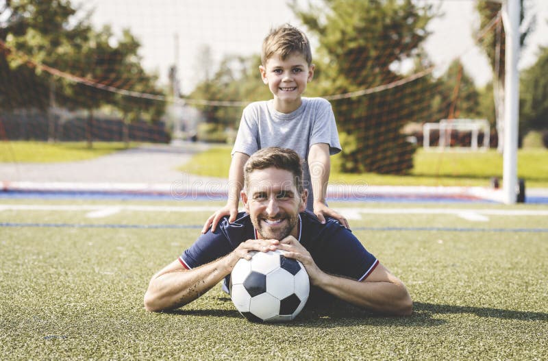 Man with Child Playing Football Outside on Field Stock Image - Image of ...