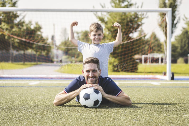 Man with Child Playing Football Outside on Field Stock Photo - Image of ...
